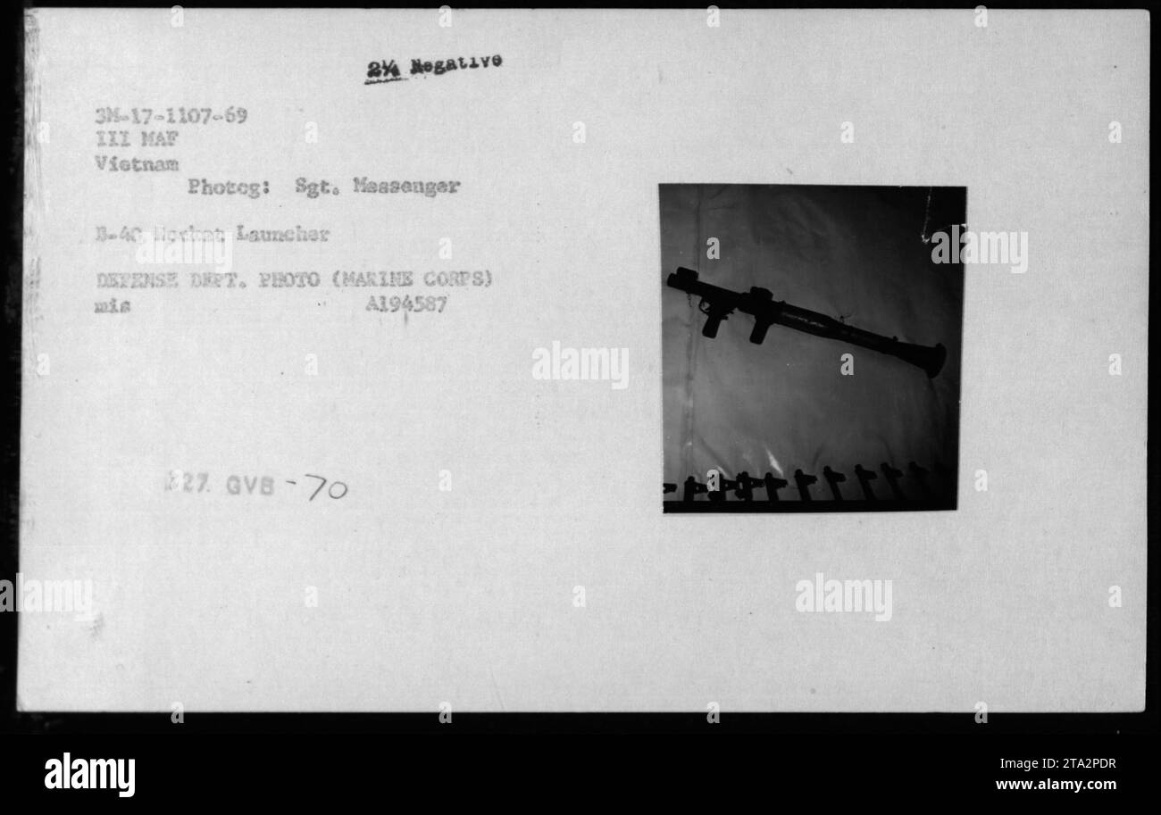 A soldier stands beside captured weapons, including a 3-40 Rocket ...