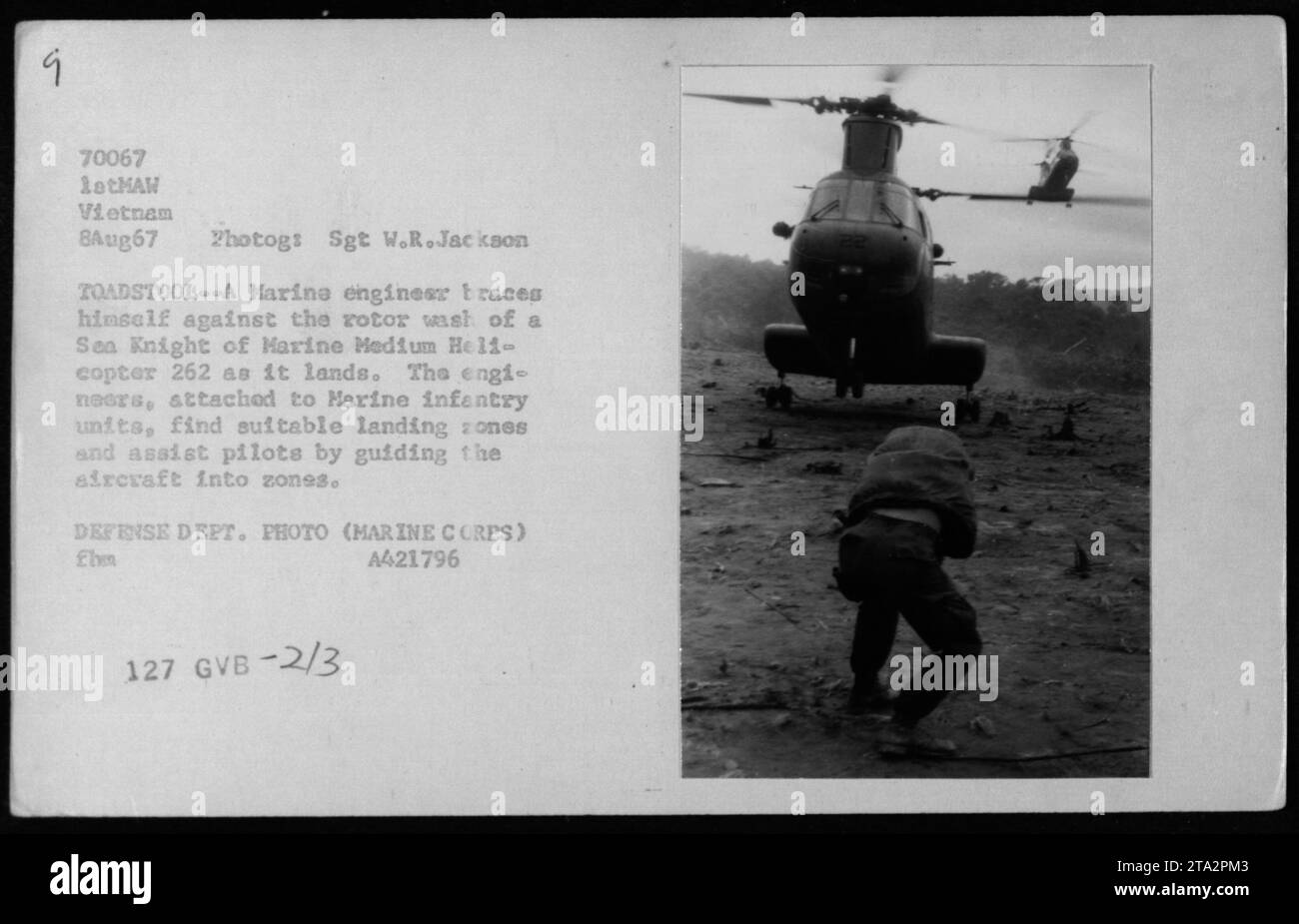 Marine engineer braces against the rotor wash of a Marine Medium ...