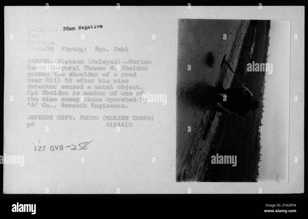 Marine Lance Corporal Thomas M. Sheldon probes the shoulder of a road ...