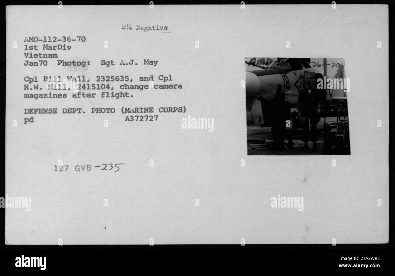 Marines, Cpl. Bill Wall and Cpl. N.W. Hill, change camera magazines ...