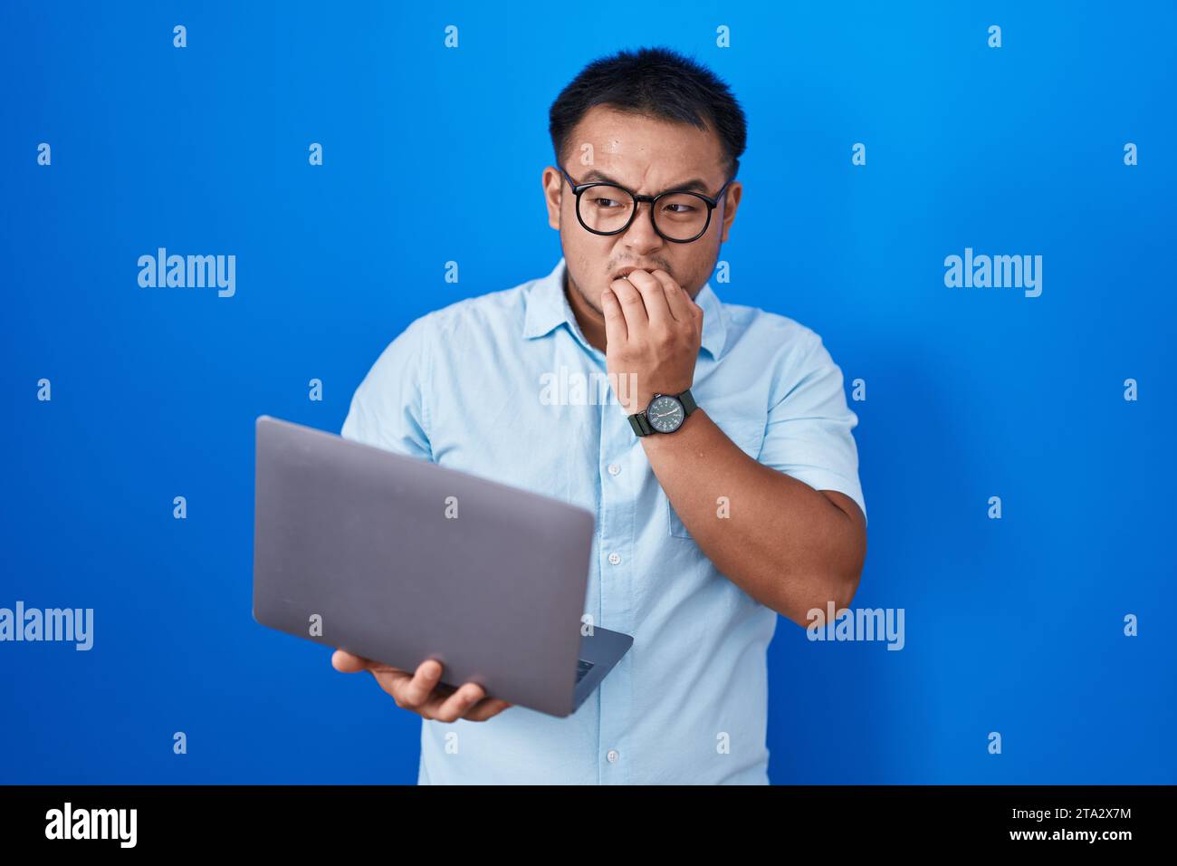 Chinese young man using computer laptop looking stressed and nervous ...