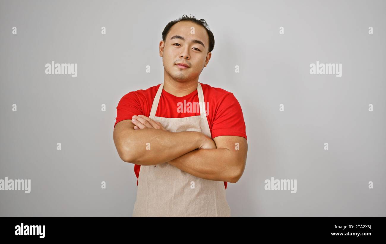 Handsome young chinese waiter stands relaxed, arms crossed with a ...