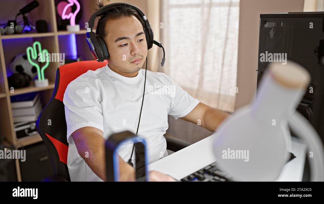 Concentrated young chinese man, a tech-enthusiast streamer, seriously ...