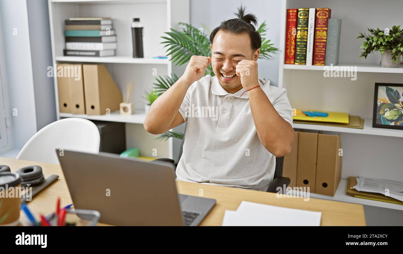 Smiling, confident young chinese man celebrates business win in the ...