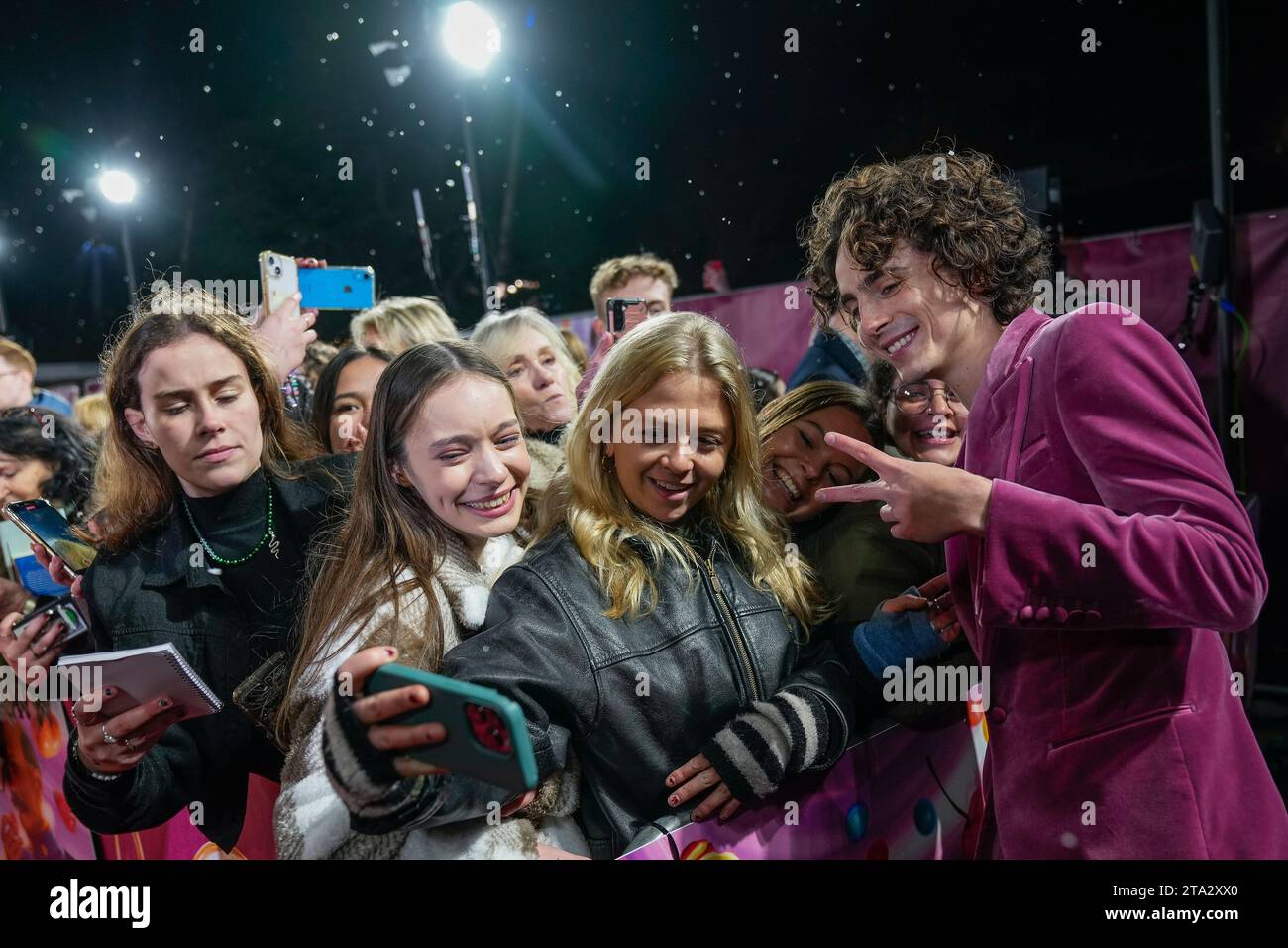 Timothee Chalamet, right, poses for photographs with fans upon arrival ...
