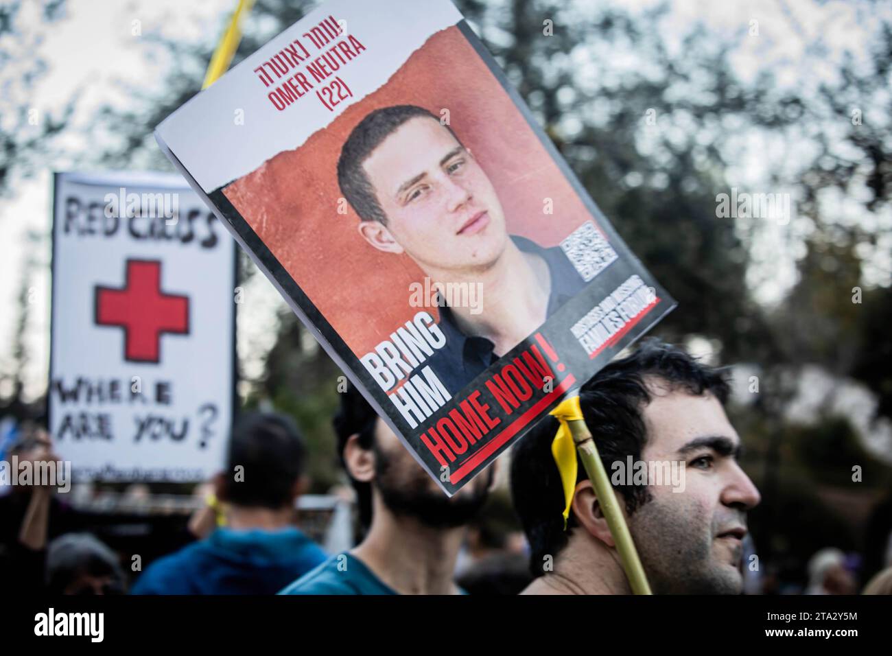 A man holds a photo of Omer Neutra during a rally calling for the ...
