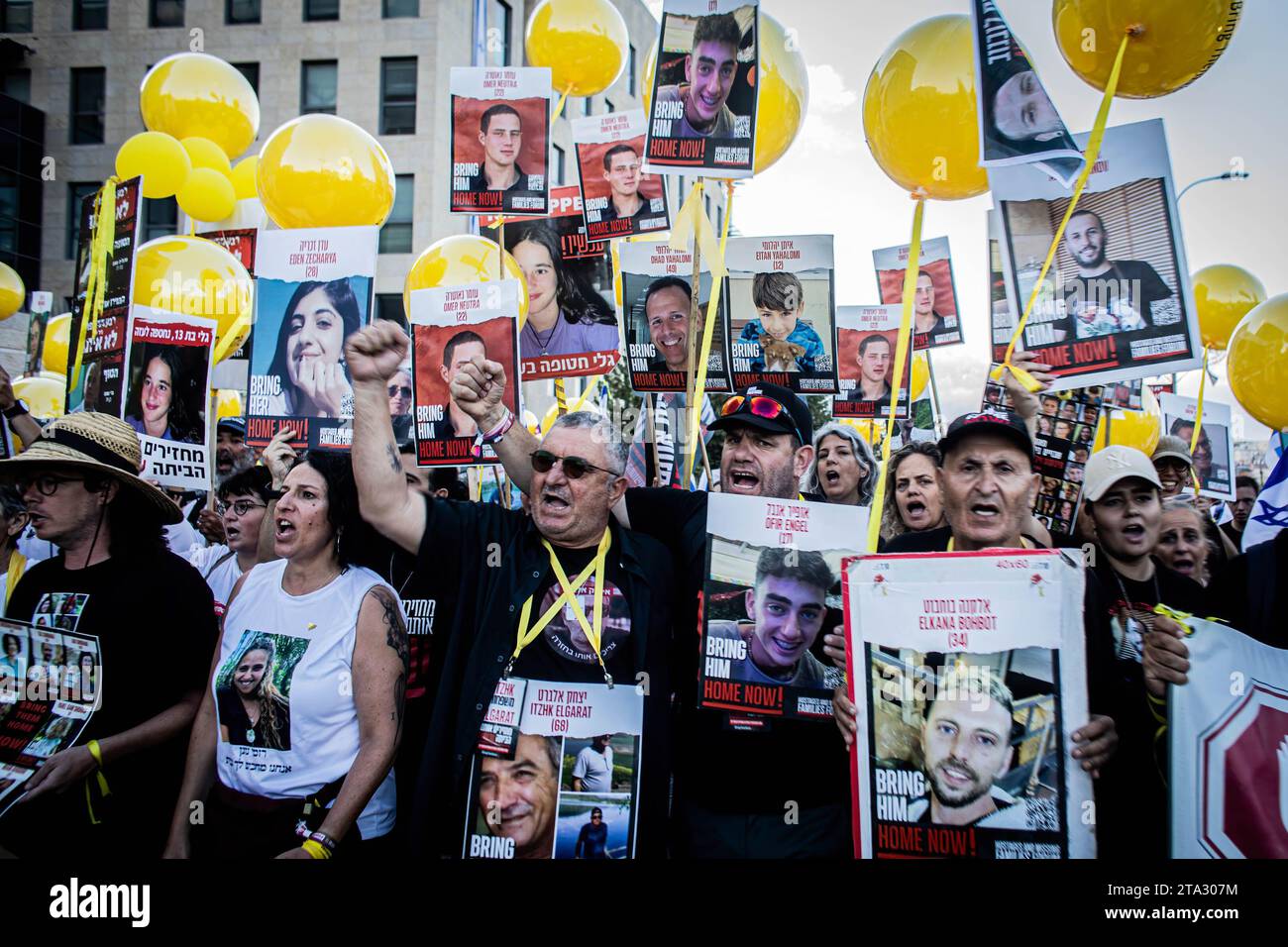 People hold balloons and photos of hostages during a march calling for ...