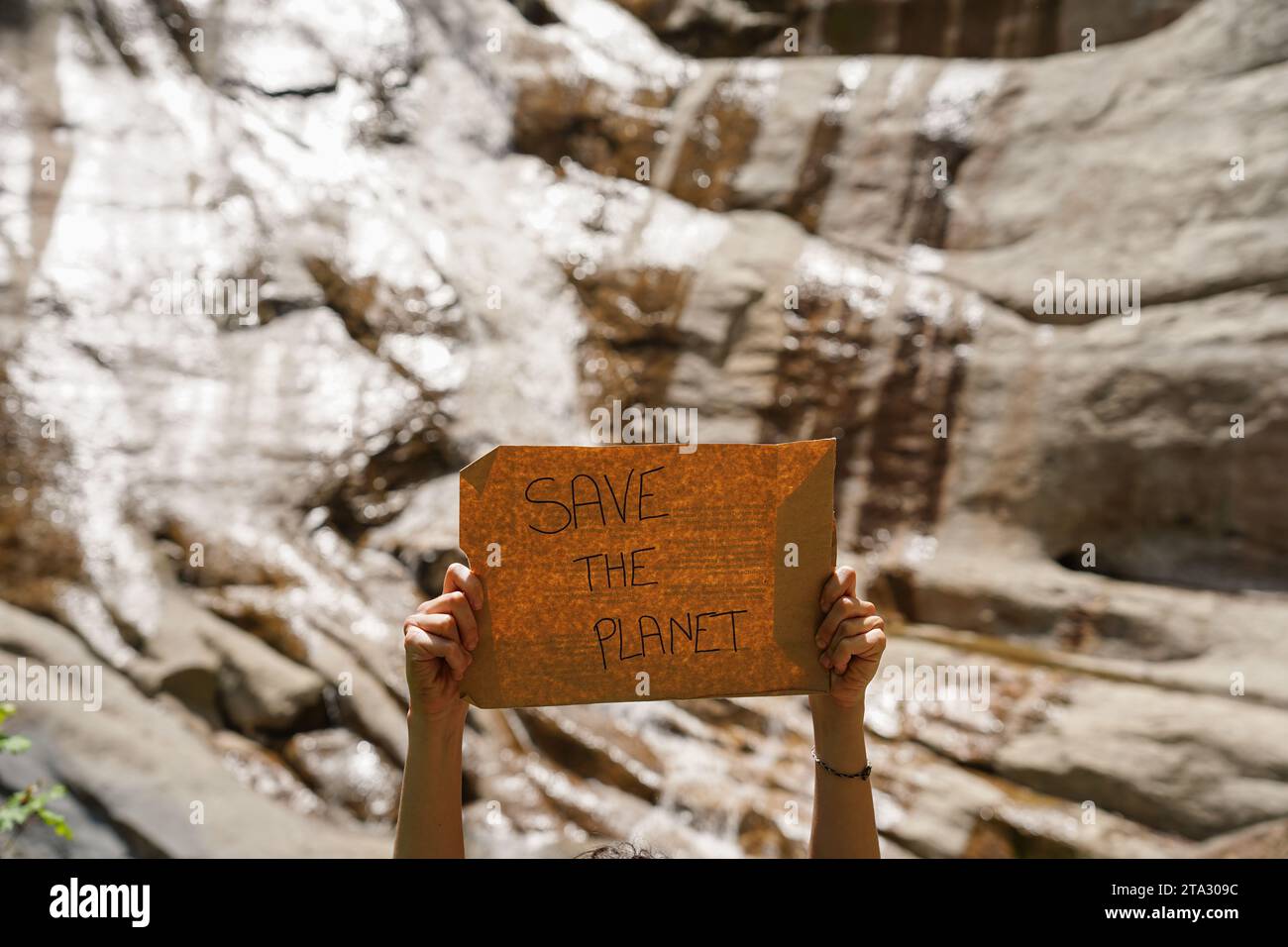 hands holding an ecological sign of save planet earth next to a ...
