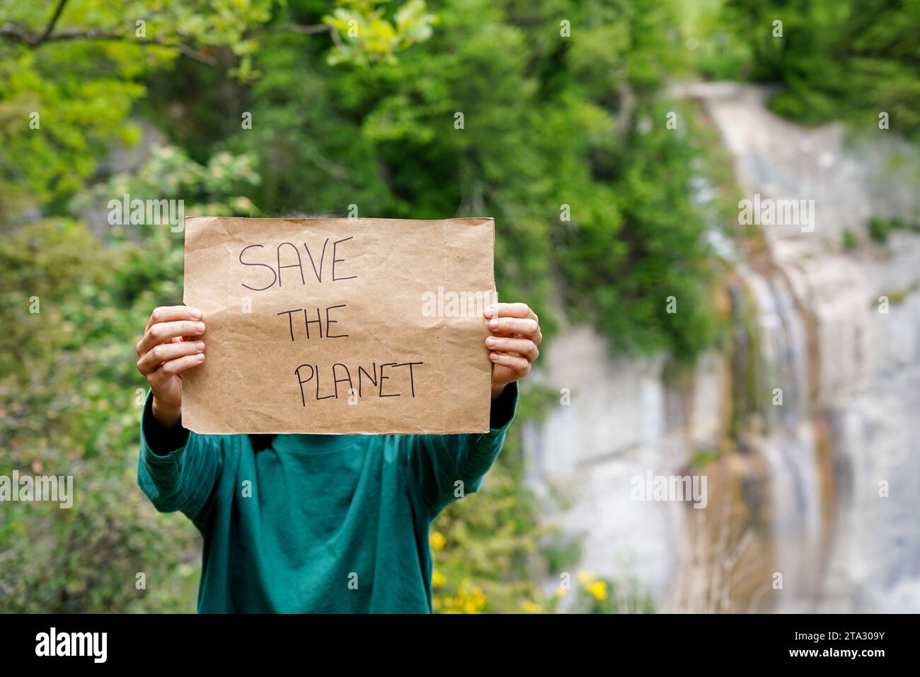 Person holding a paper with ecological message of save the planet next ...