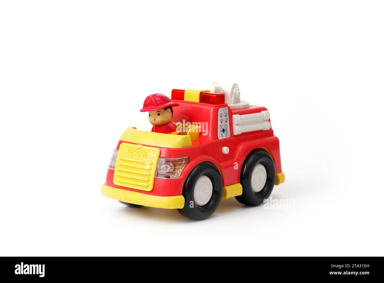Children's toy red fire truck with driver in the cabin, isolated on ...