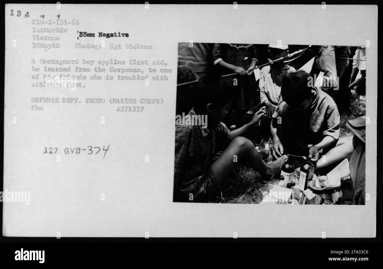 Vietnamese Montagnard boy applies first aid, learned from a Corpsman, to a friend with athlete's ...