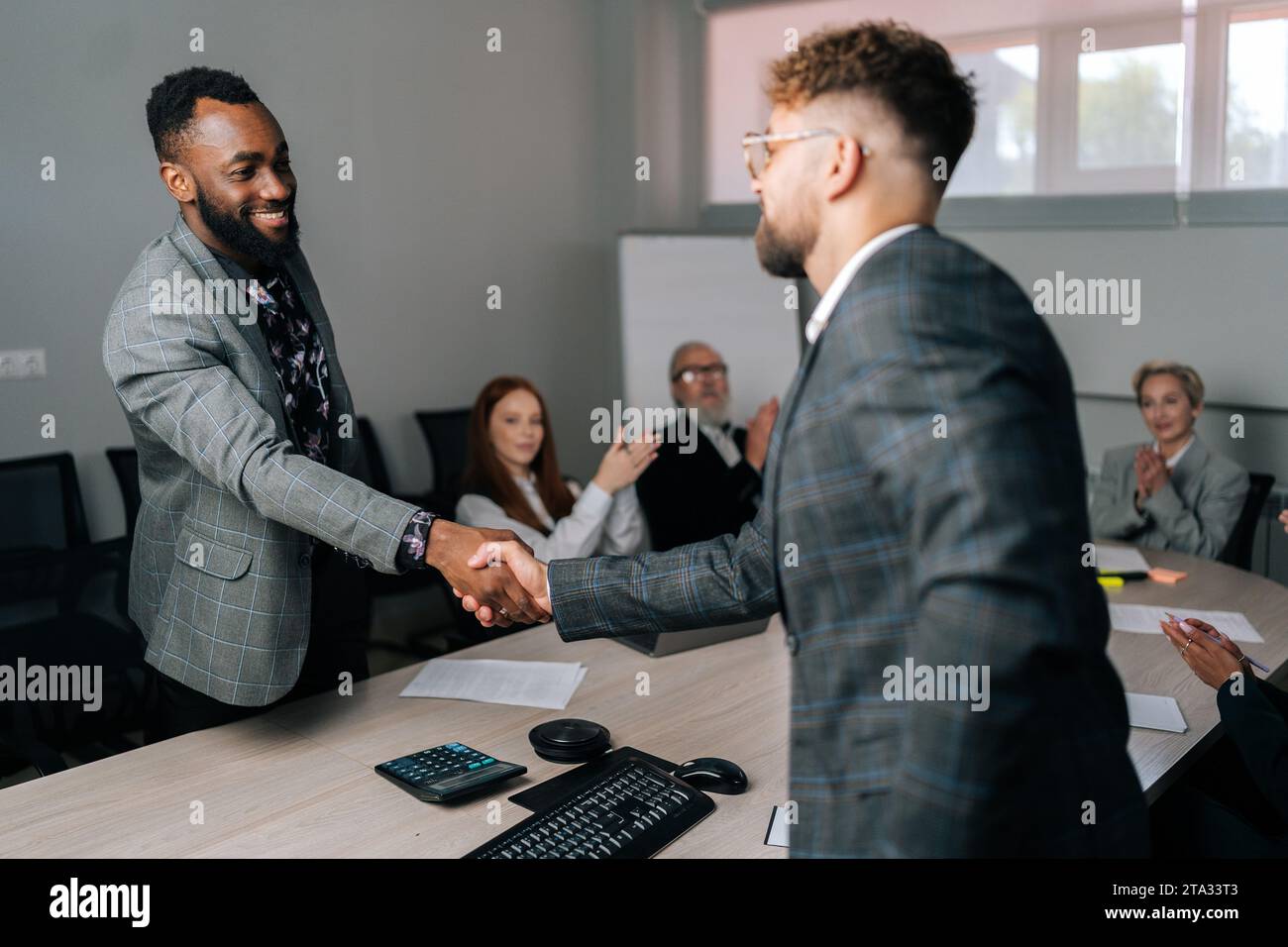 Back view handshaking of happy African-American and Caucasian ...