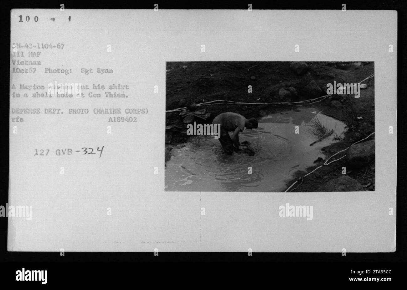 Marine Corps Sgt. Ryan A. Marino washes his shirt in a shell hole at ...