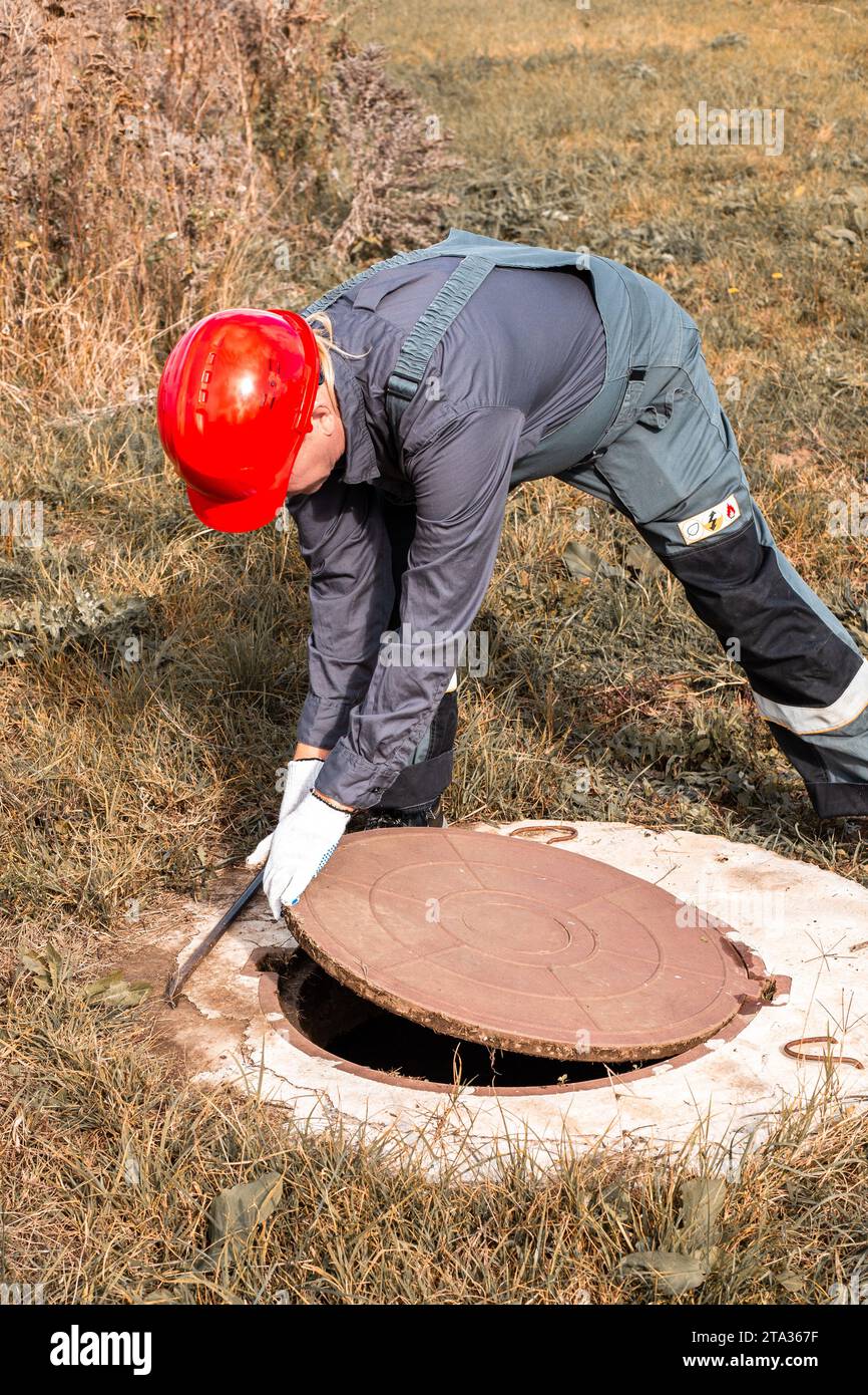 The plumber opens the well manhole for inspection and maintenance Stock ...