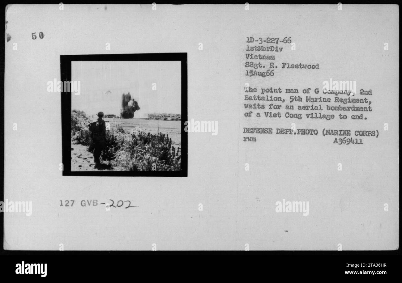 "An American Marine in Vietnam stands ready as an aerial bombardment ...