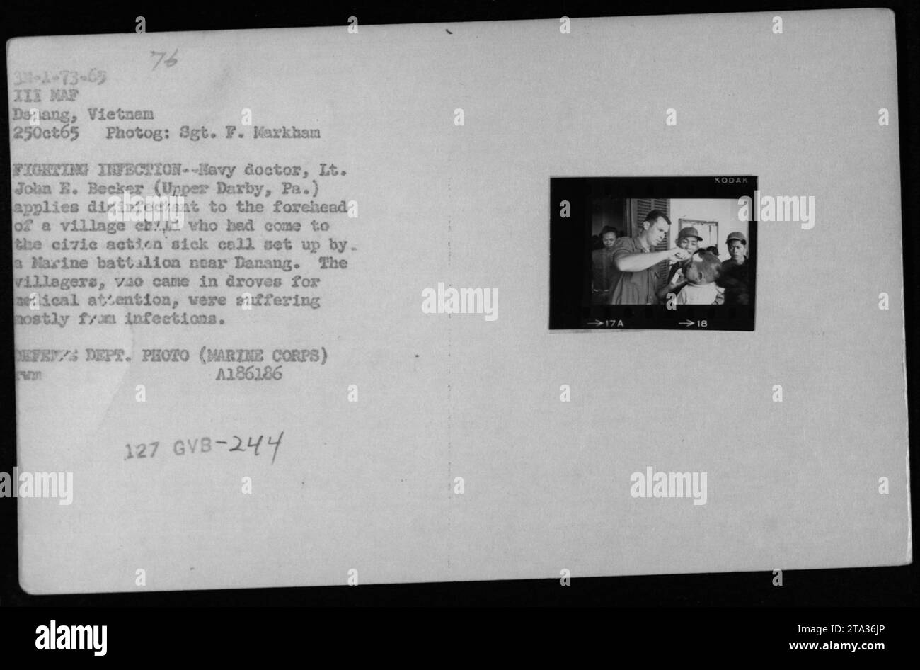 Navy doctor, Lt. John E. Becker, applies disinfectant to the forehead ...