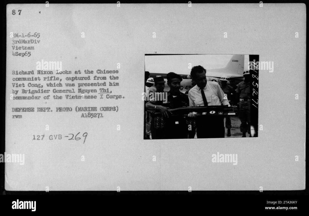 Richard Nixon examines a Chinese communist rifle captured from the Viet ...