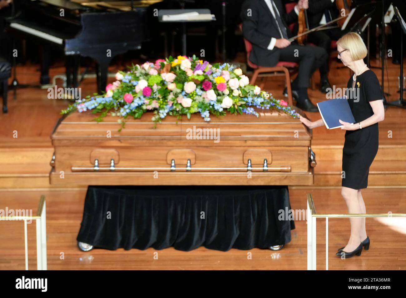 Kathryn Cade touches the casket after speaking during a tribute service ...