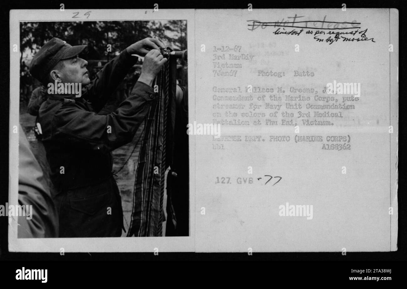 General Wallace H. Greene affixes a Heavy Unit Commendation streamer to ...