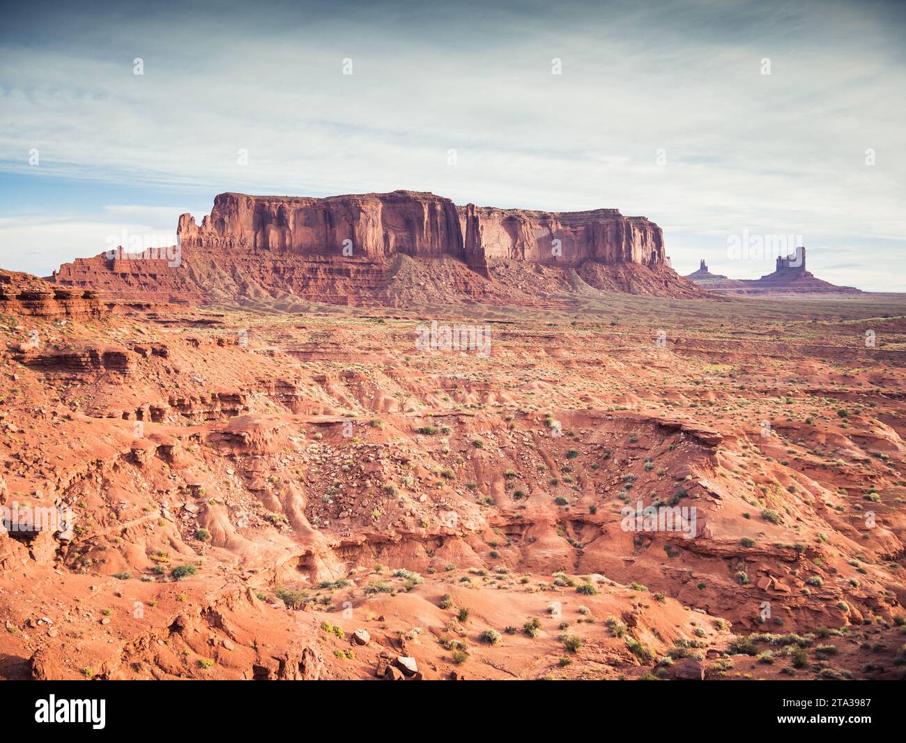 Two riders on horseback galloping across a desert landscape with rocky ...
