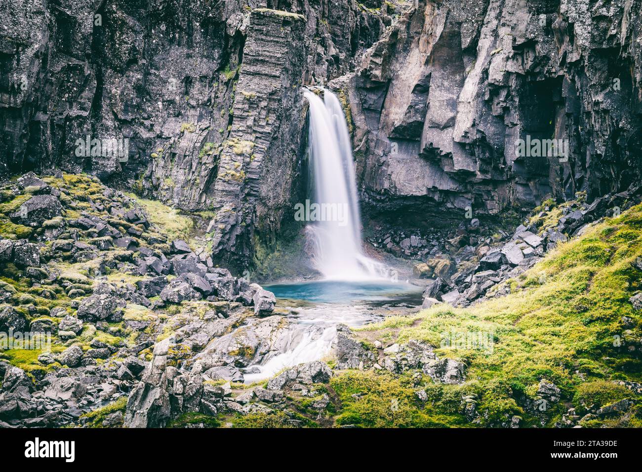 A majestic waterfall cascades down a sheer face of a towering cliff ...