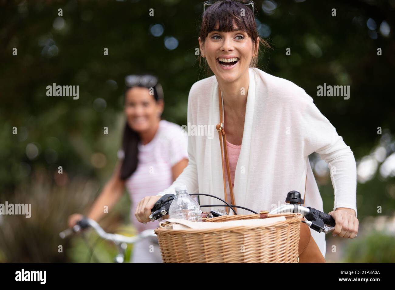 two friends on bikes outdoors smiling Stock Photo - Alamy