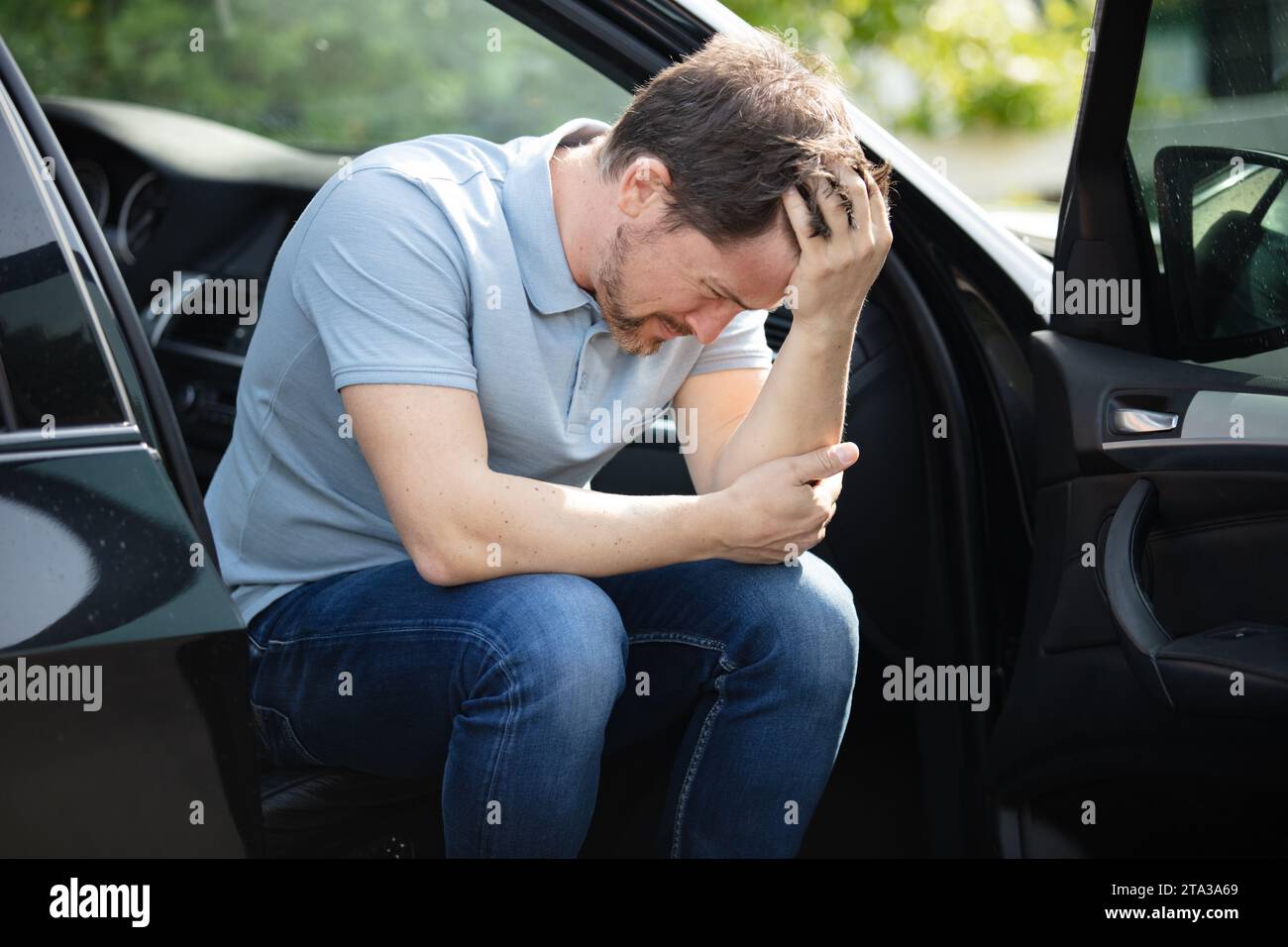 sad driver after car accident holding hand on his head Stock Photo - Alamy