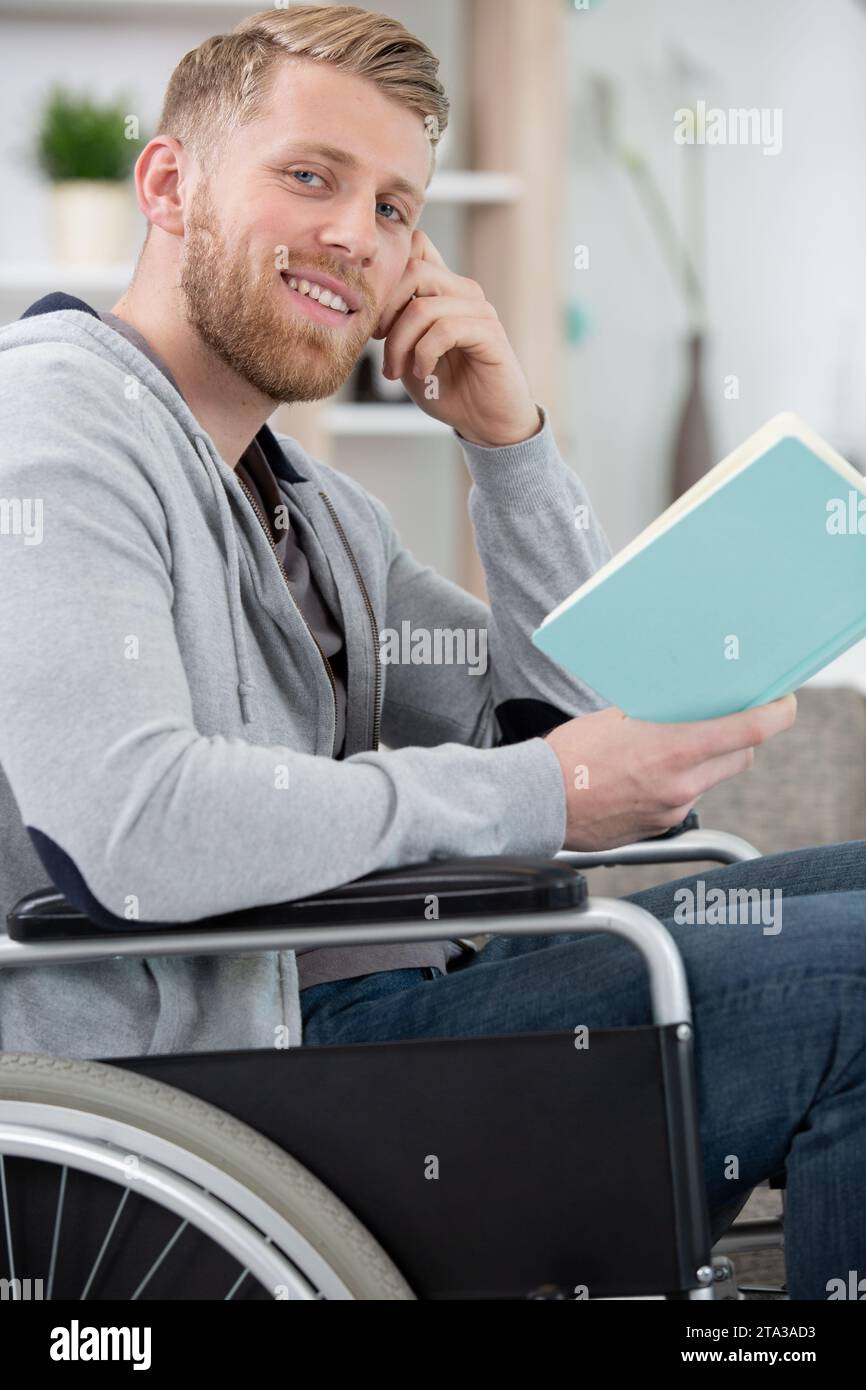 disabled man on wheelchair reading book Stock Photo - Alamy
