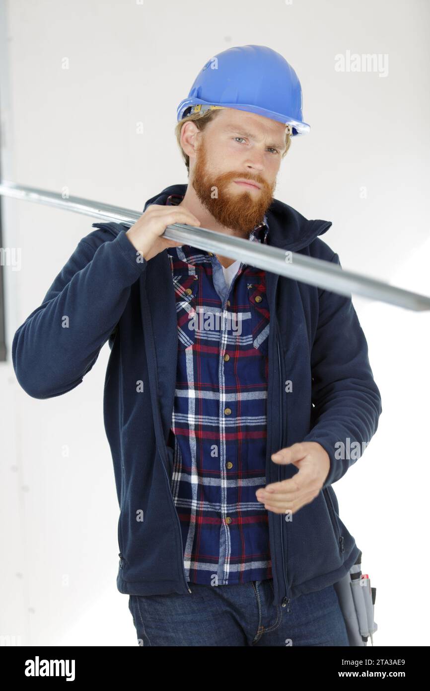 workman carrying a metal frame Stock Photo - Alamy