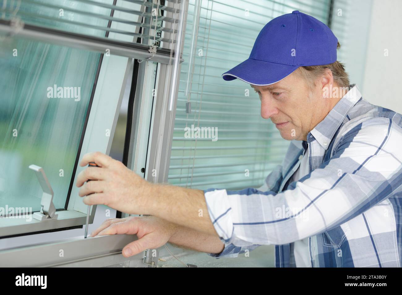young repairman fixing window frame in room Stock Photo - Alamy
