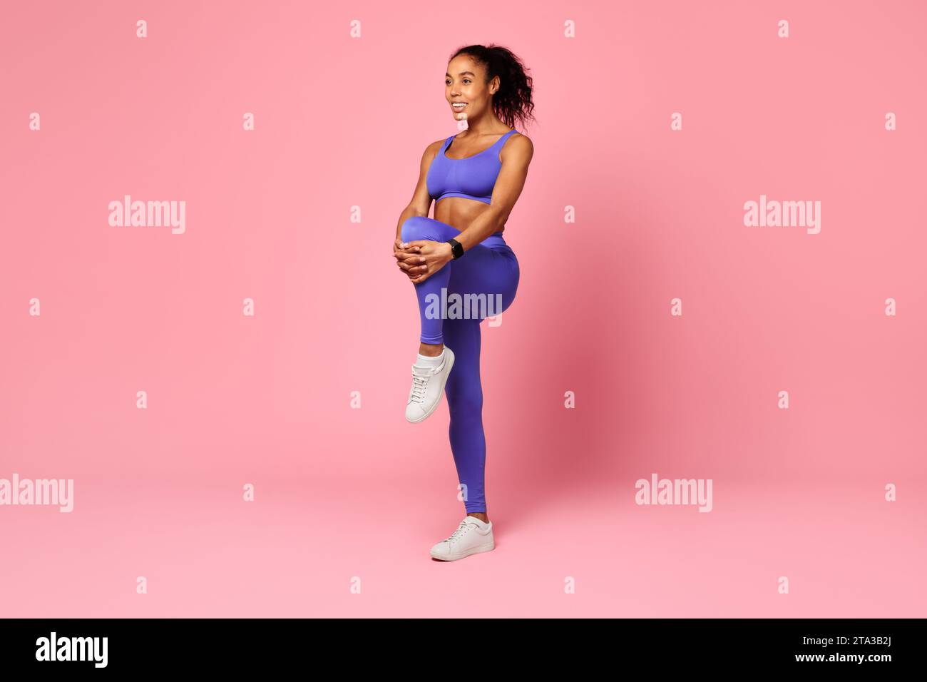 african lady stretching leg muscles holding knee to chest, studio Stock ...