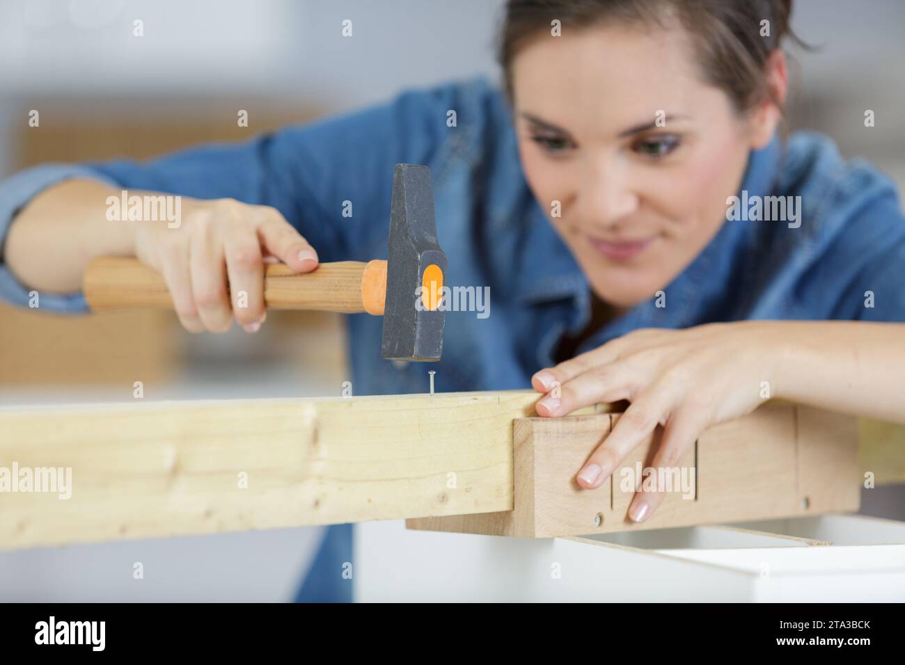 young woman using a hammer Stock Photo - Alamy