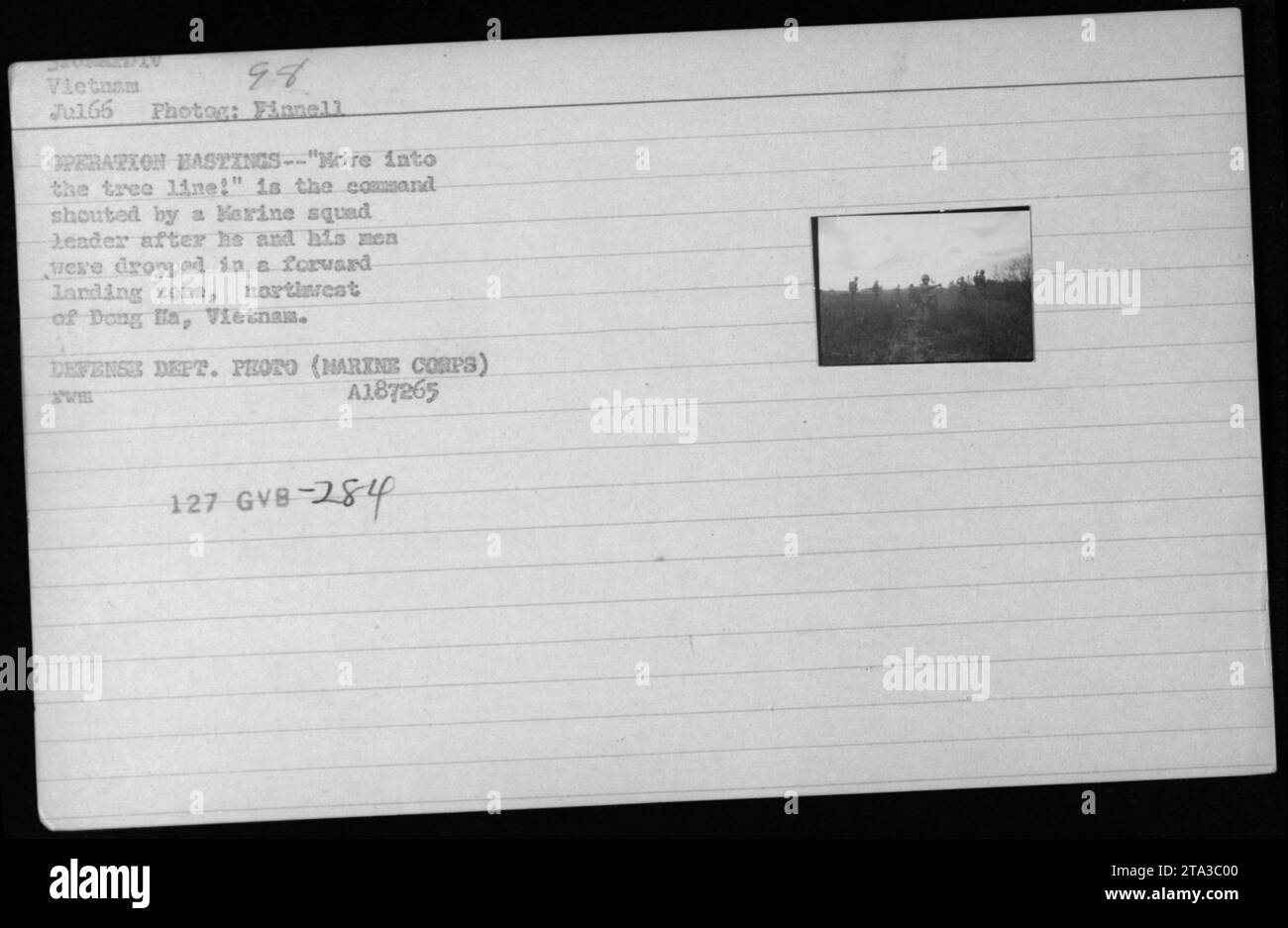 Marine Corps squad leader instructs his men to move into the tree line ...