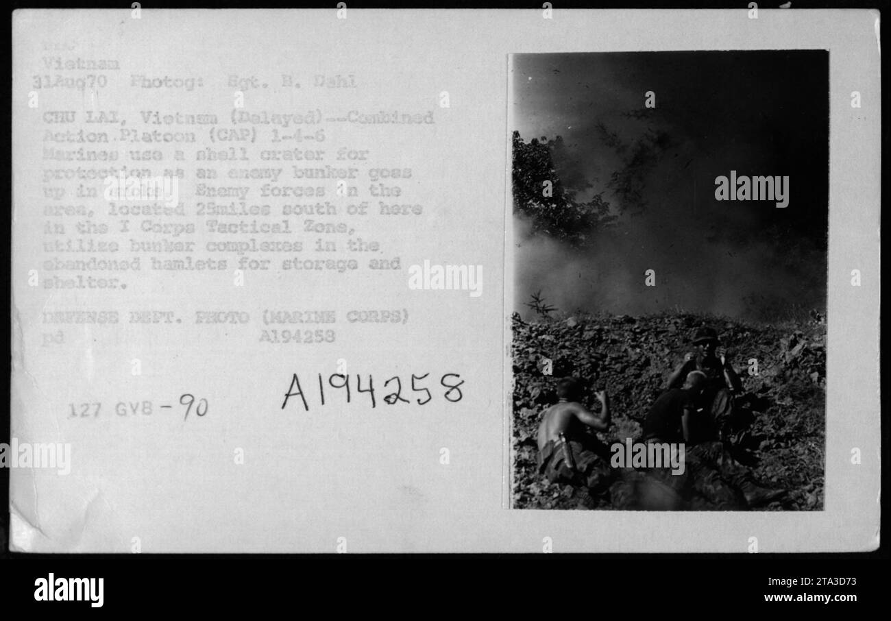 Marines of CAP 1-4-6 take cover in a shell crater while an enemy bunker ...