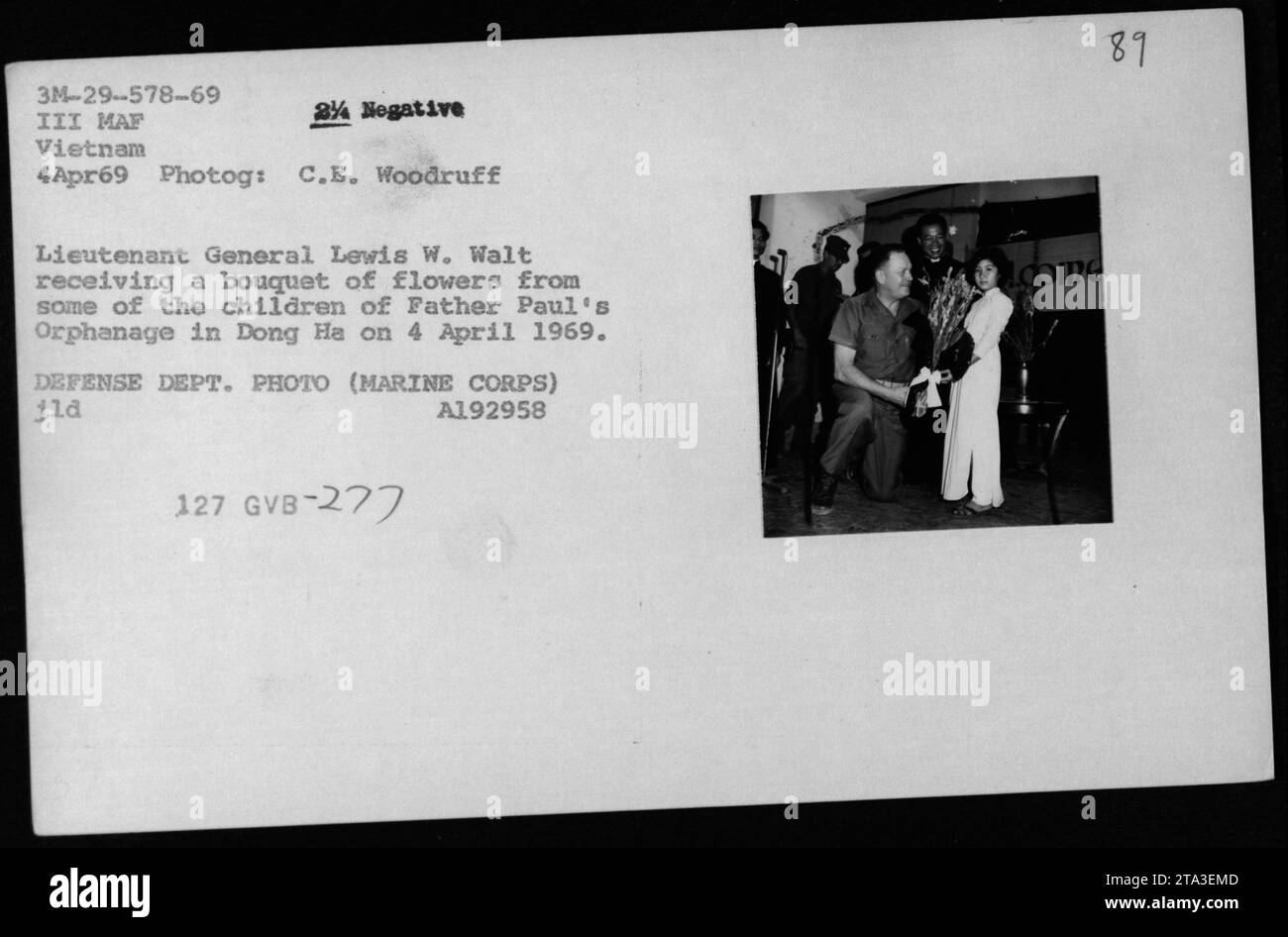 Lt Gen Lewis W. Walt receives flowers from children at Father Paul's ...