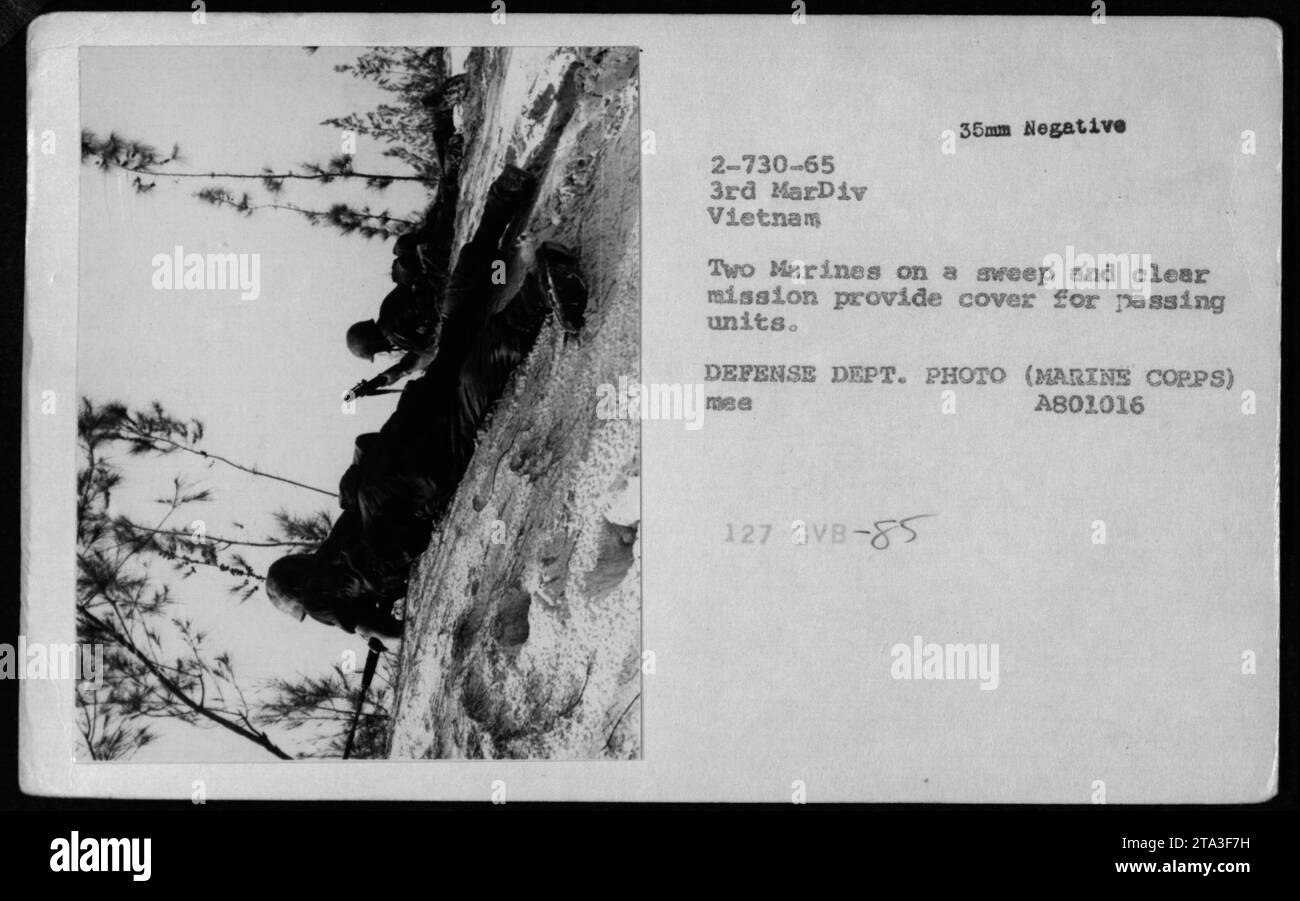 Two Marines provide cover for passing units during a sweep and clear ...