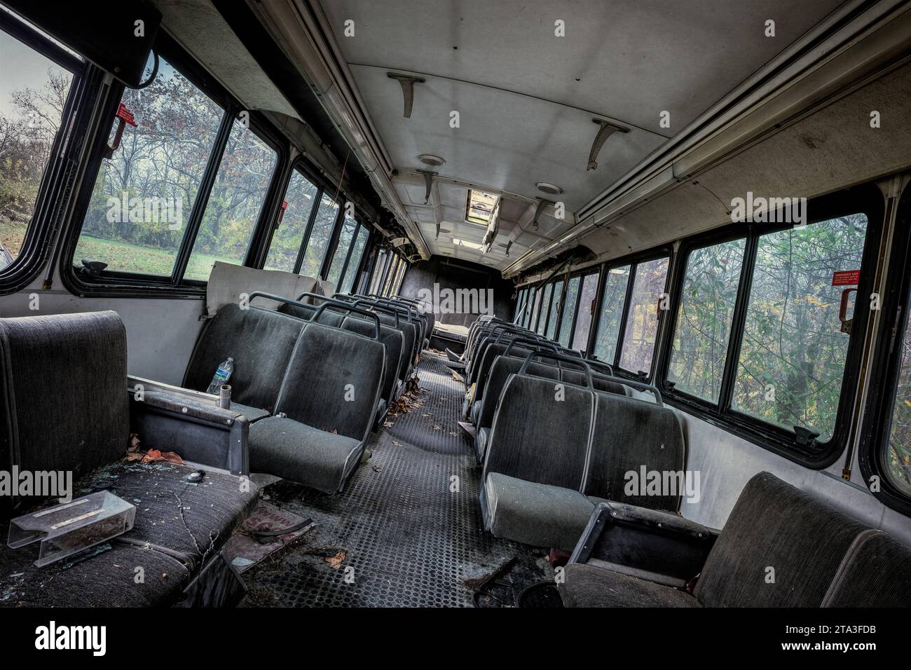 Interior of abandoned trashed commercial bus left behind in the forest ...