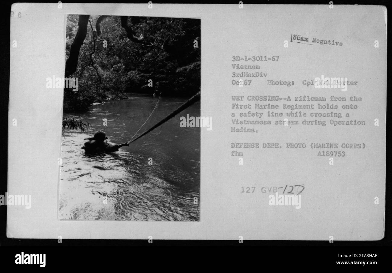 Marine rifleman crossing a Vietnamese stream during Operation Medina in ...