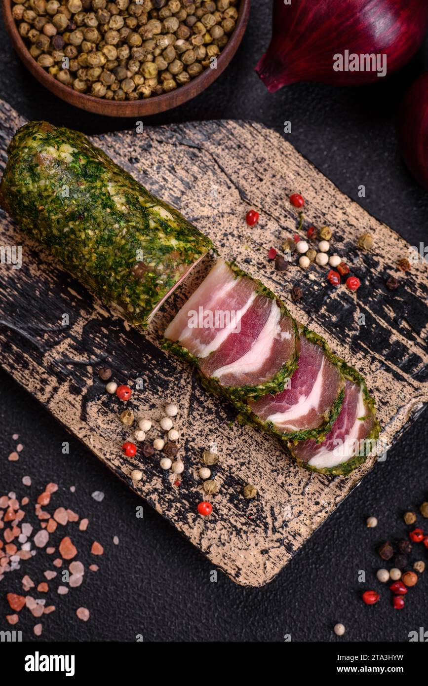 Delicious fresh bacon stripes with spices and salt on a dark concrete ...