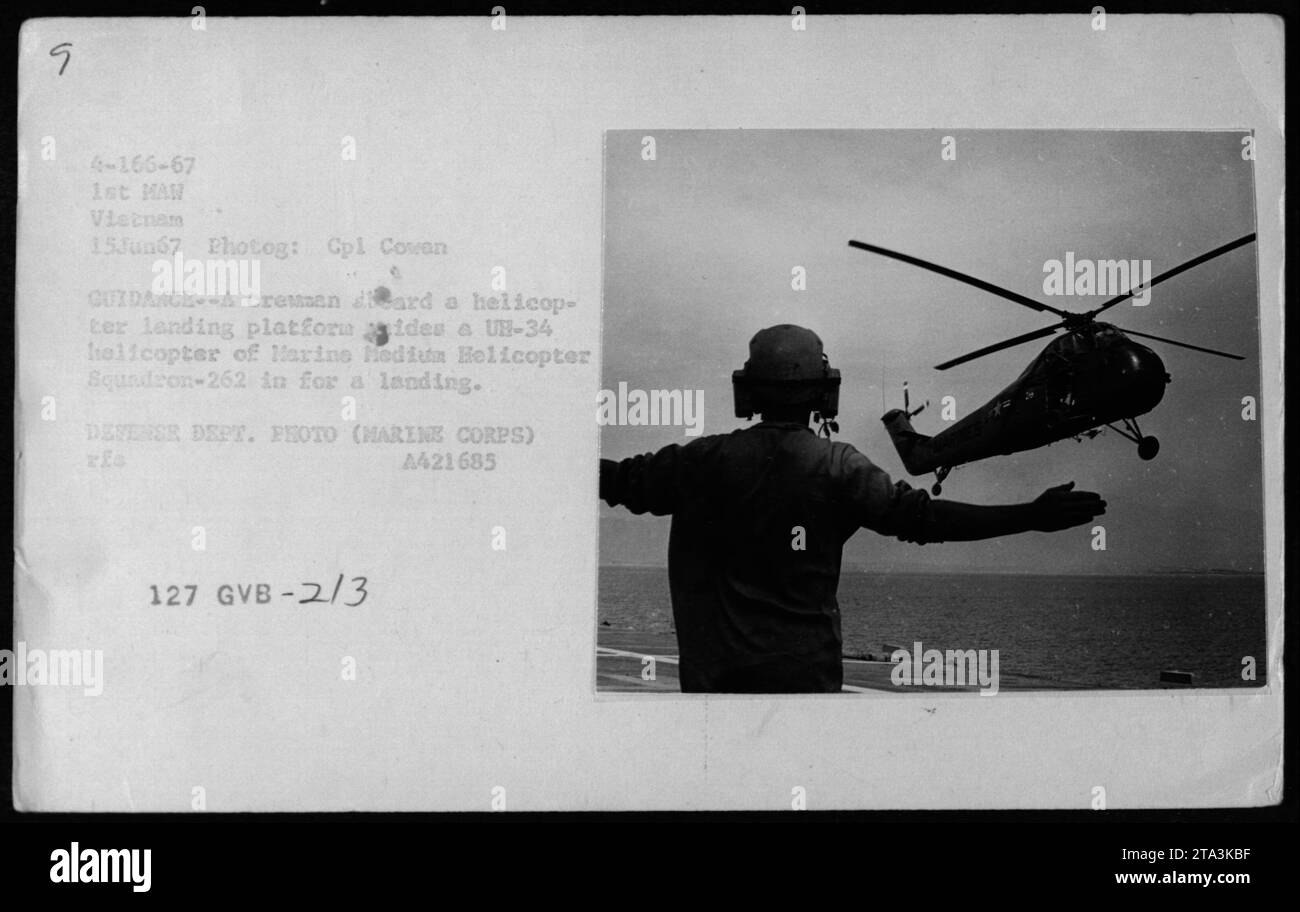 A crewman guides a UN-34 helicopter of Marine Medium Helicopter ...