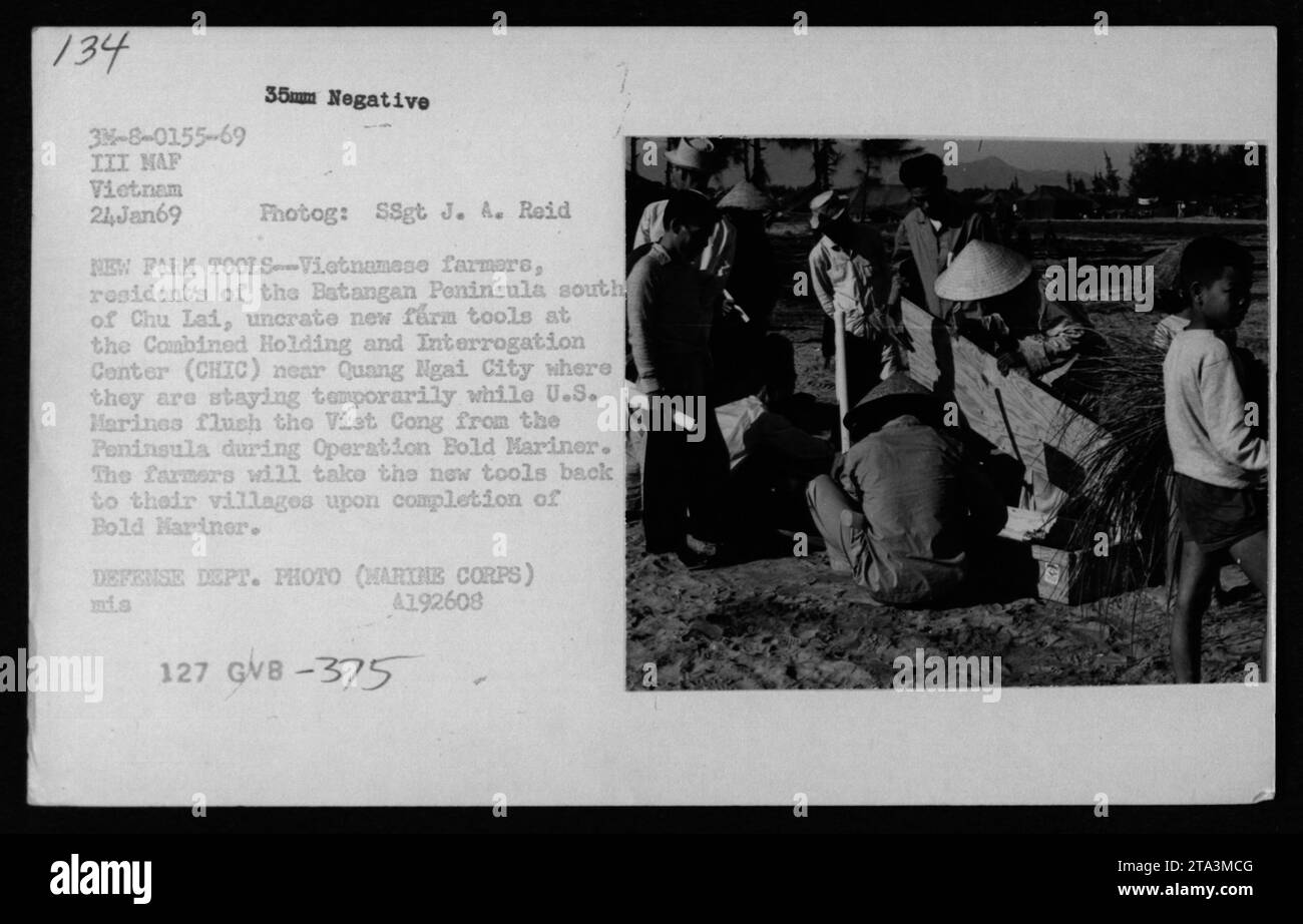 Vietnamese farmers uncrate new farm tools at the Combined Holding and ...