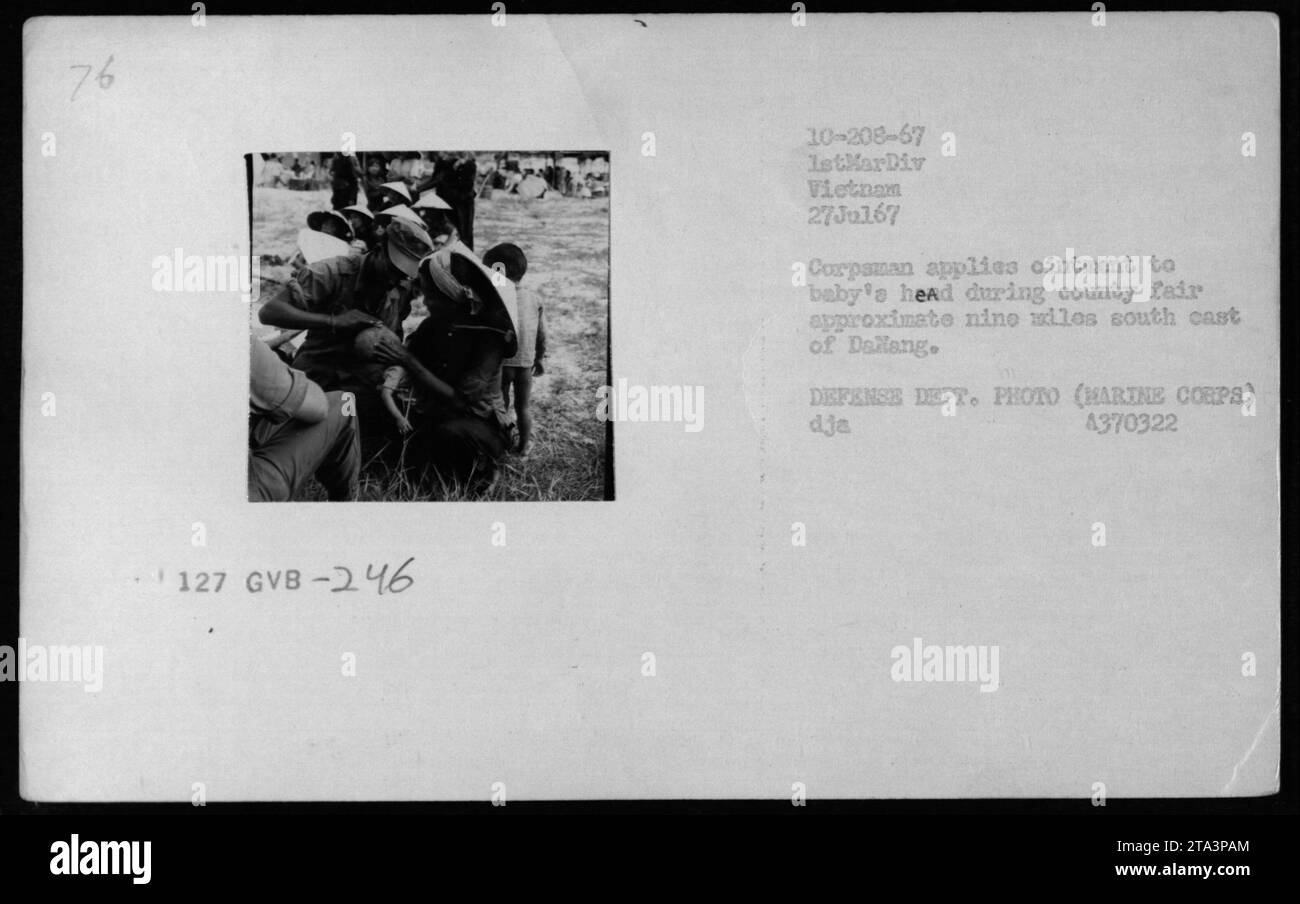 A corpsman applies ointment to a baby's head during a MEDCAP event nine ...