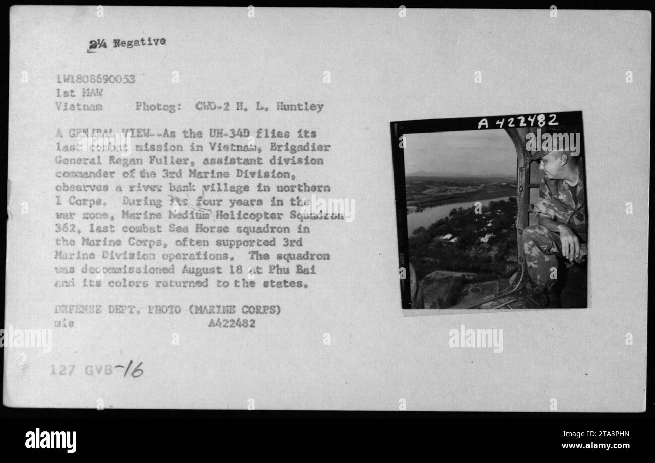 Brigadier General Regan Fuller observes a river bank village in ...