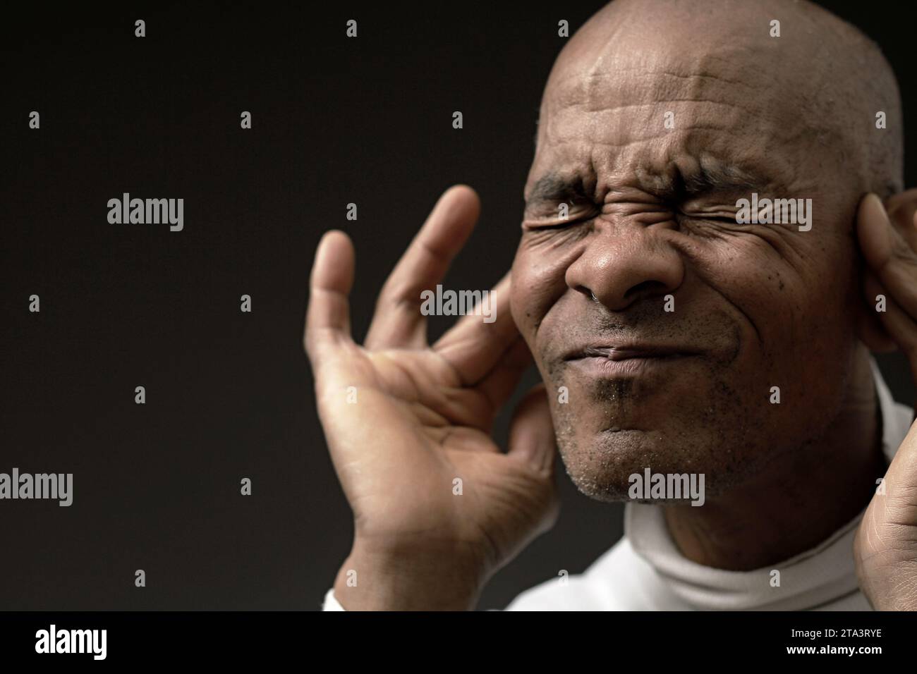 suffering from deafness and hearing loss on grey black background with ...