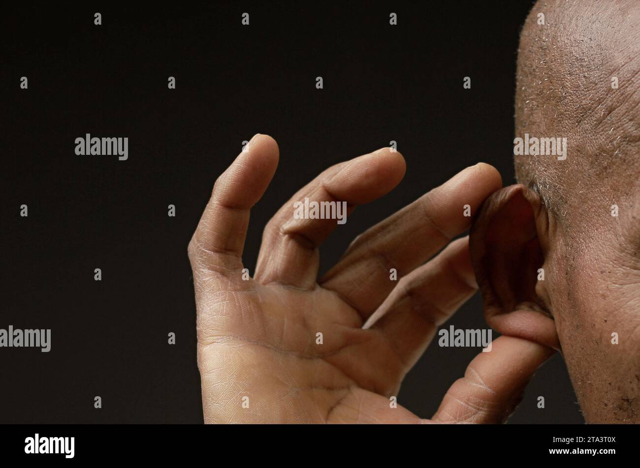 suffering from deafness and hearing loss on grey black background with ...