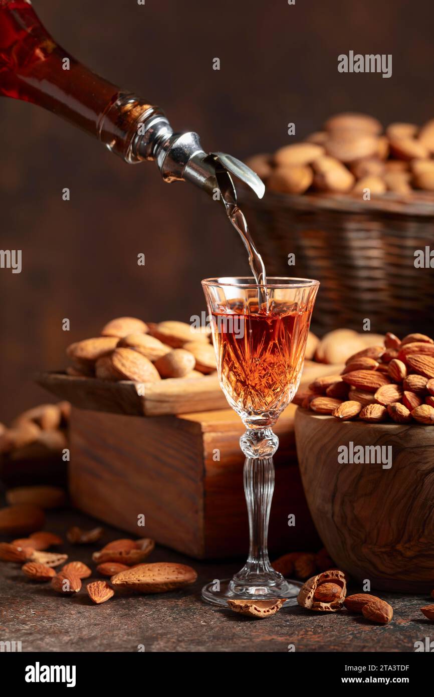 Italian liqueur Amaretto with almonds nuts on a vintage table. Liqueur ...