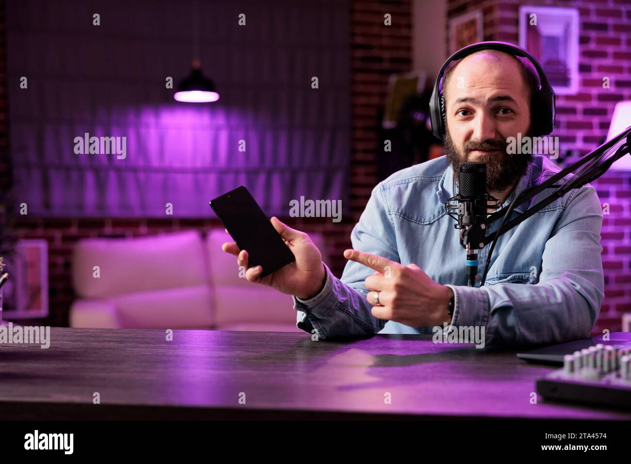 Portrait of tech vlogger reviewing newly released smartphone in rgb ...