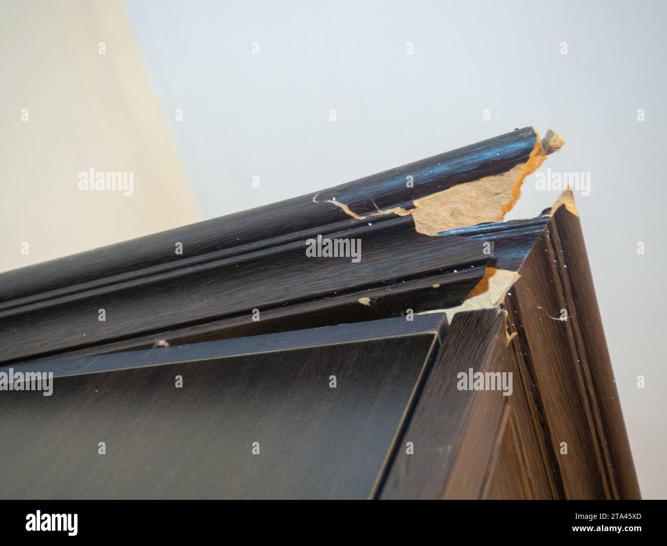 corner of the cabinet is broken. Crack in a wooden cabinet. Breakage ...