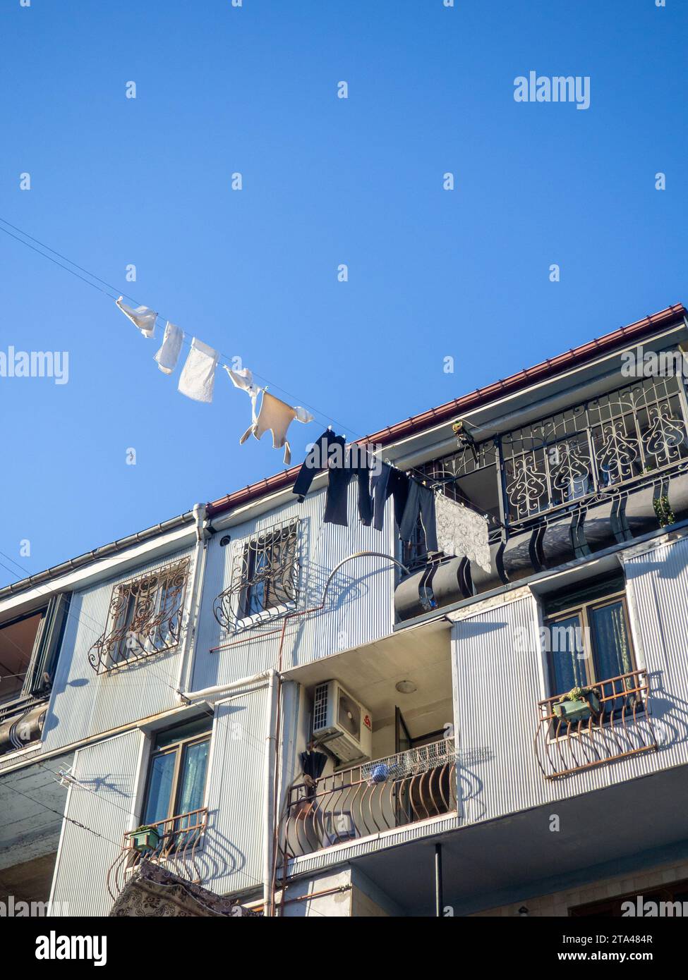 Laundry is dried on a long line on the street. Local life in Asia ...