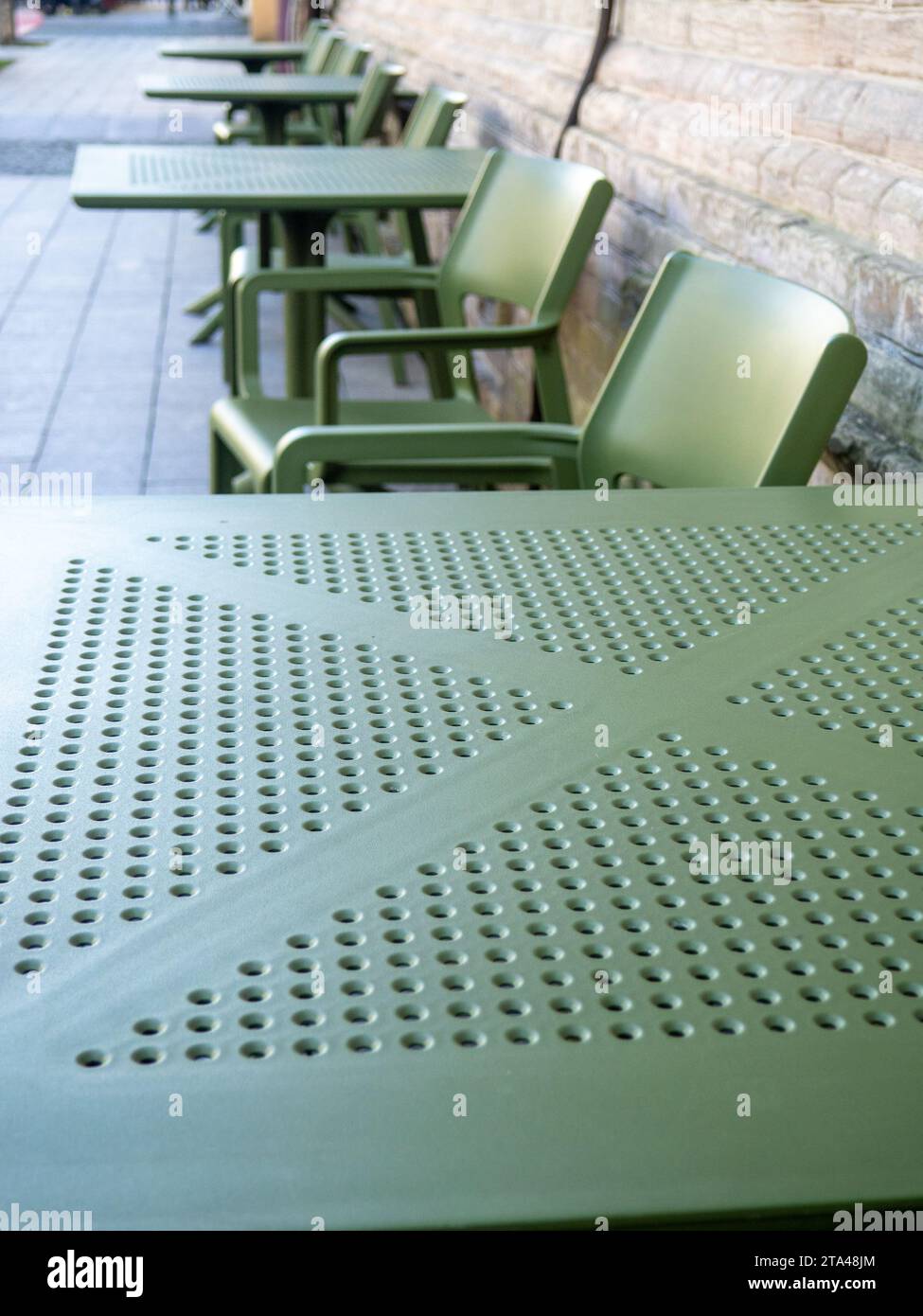 Empty plastic tables in a cafe. Green chairs and tables outside. The ...